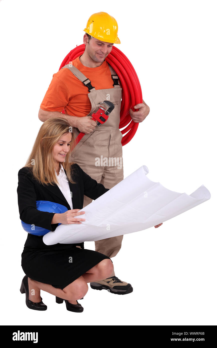 Female architect explaining lay-out to plumber Stock Photo - Alamy