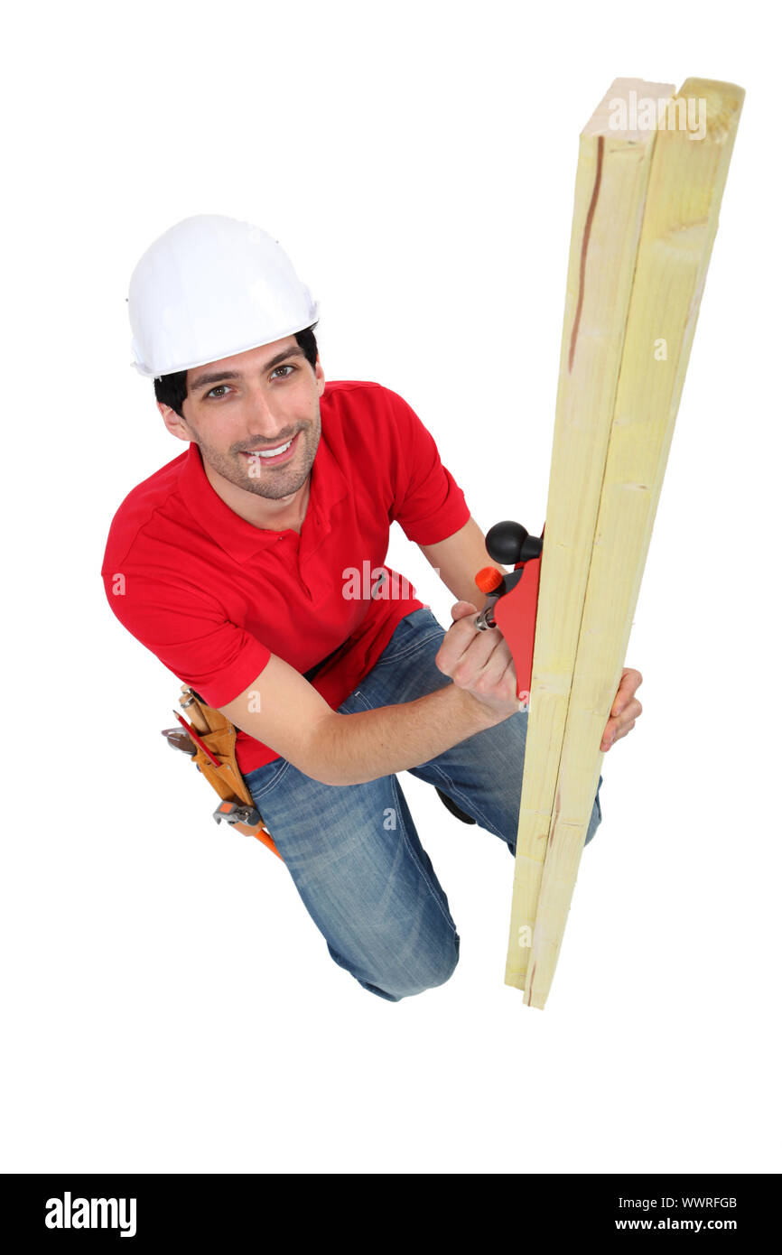 Tradesman using a plane to smooth a plank of wood Stock Photo - Alamy