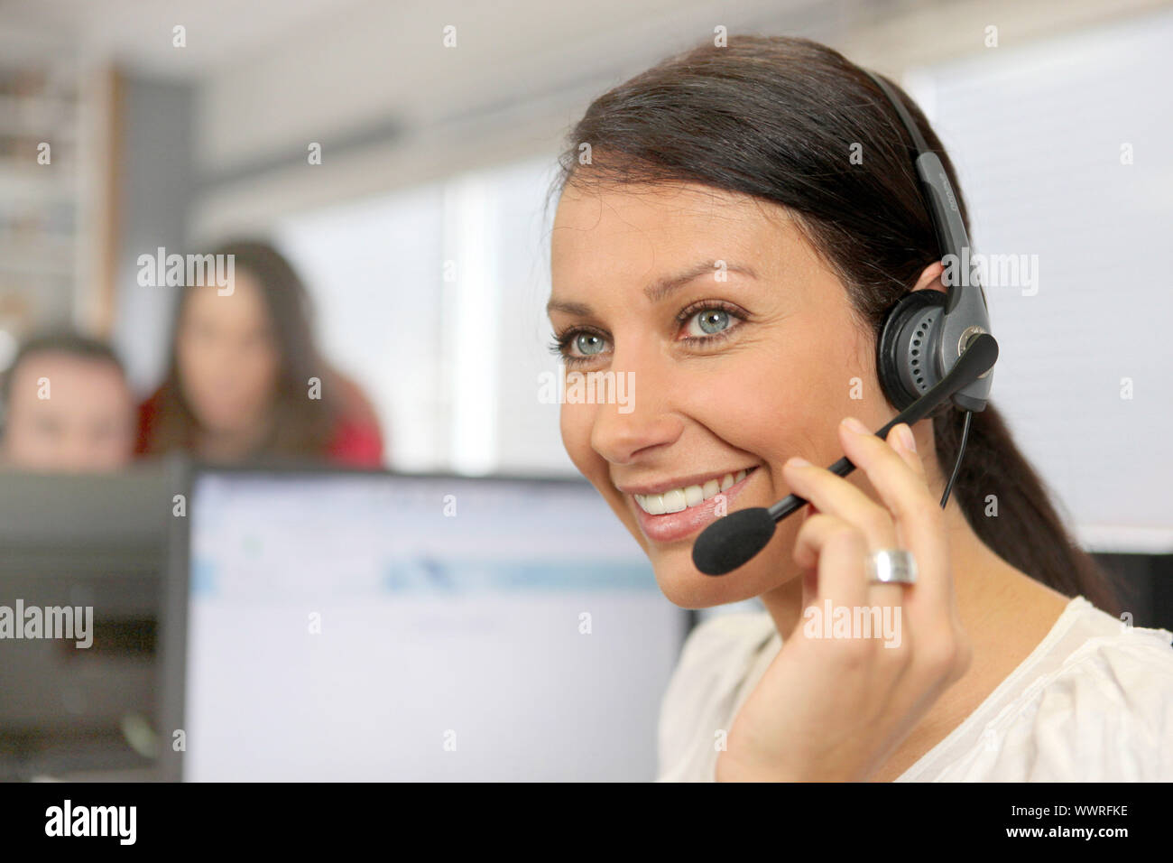 Smiling employee with headset Stock Photo - Alamy
