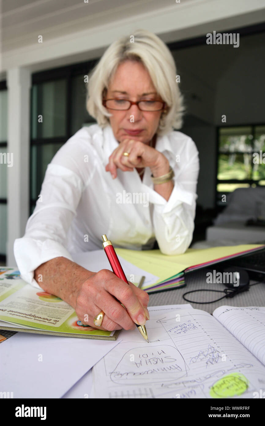 Mature woman writing Stock Photo - Alamy