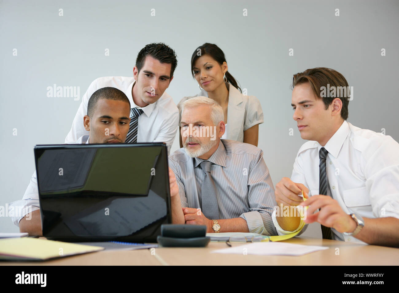 Business team sitting at a computer Stock Photo - Alamy
