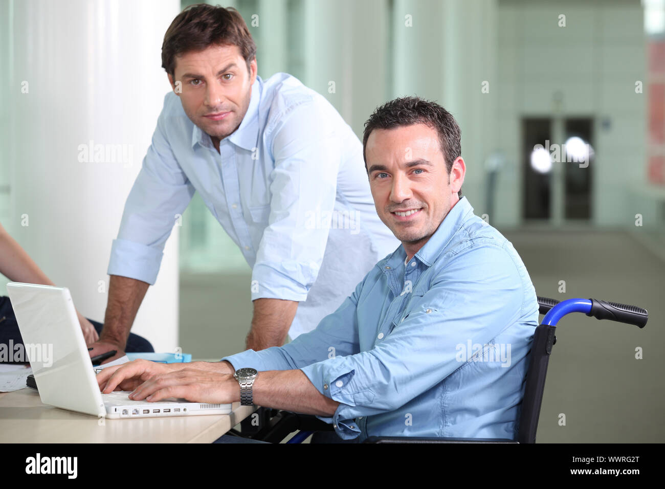 Disabled worker with colleague Stock Photo - Alamy