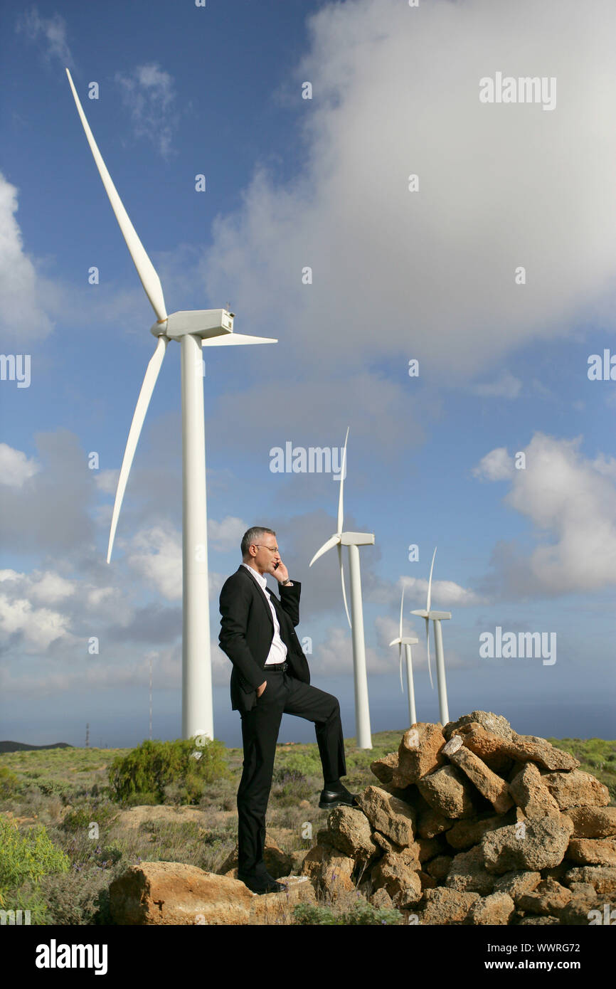 Man using a mobile phone next to wind turbines Stock Photo - Alamy