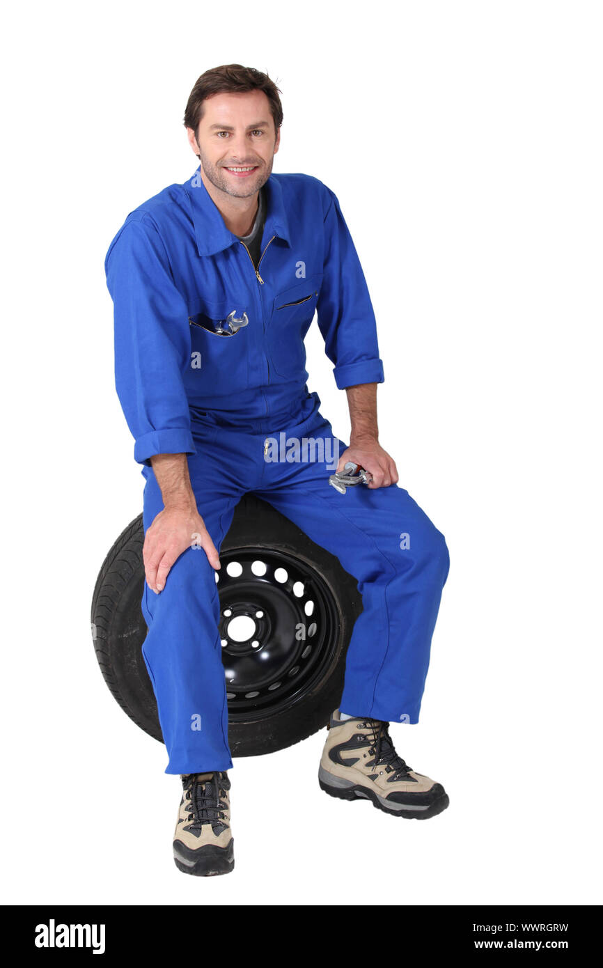 mechanic sitting on a tyre Stock Photo - Alamy