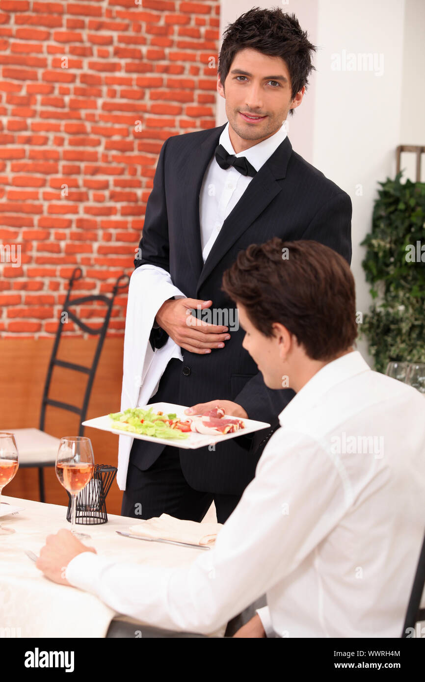 Waiter deliver in meal in restaurant Stock Photo - Alamy