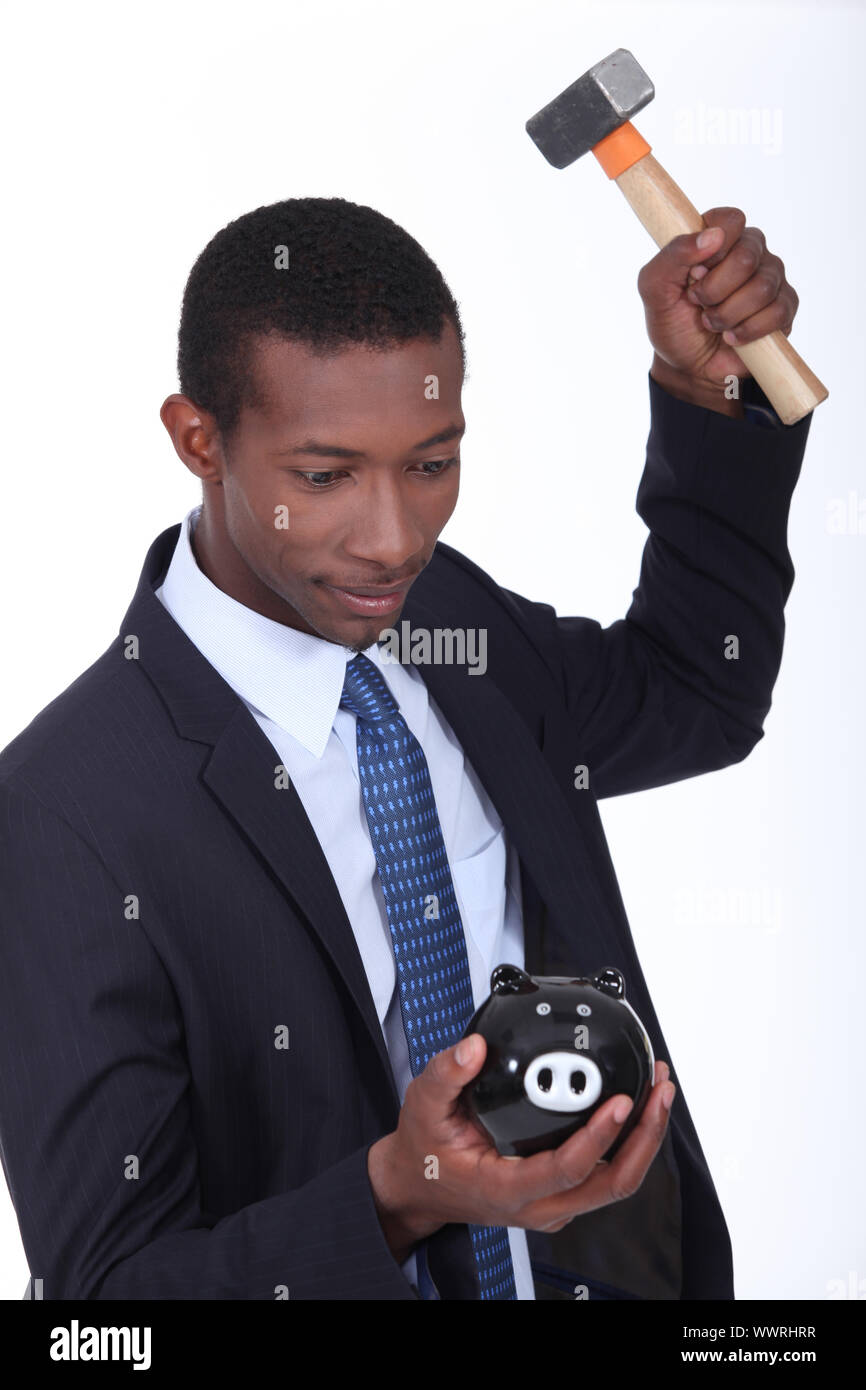 Man breaking a piggy bank open with a hammer Stock Photo - Alamy