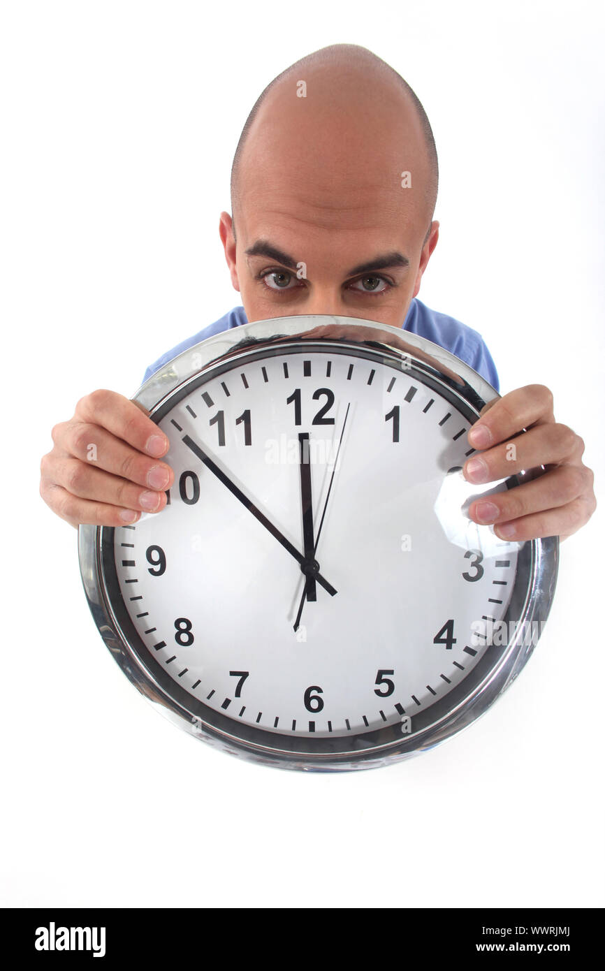 Bald man carrying a clock, studio shot Stock Photo - Alamy