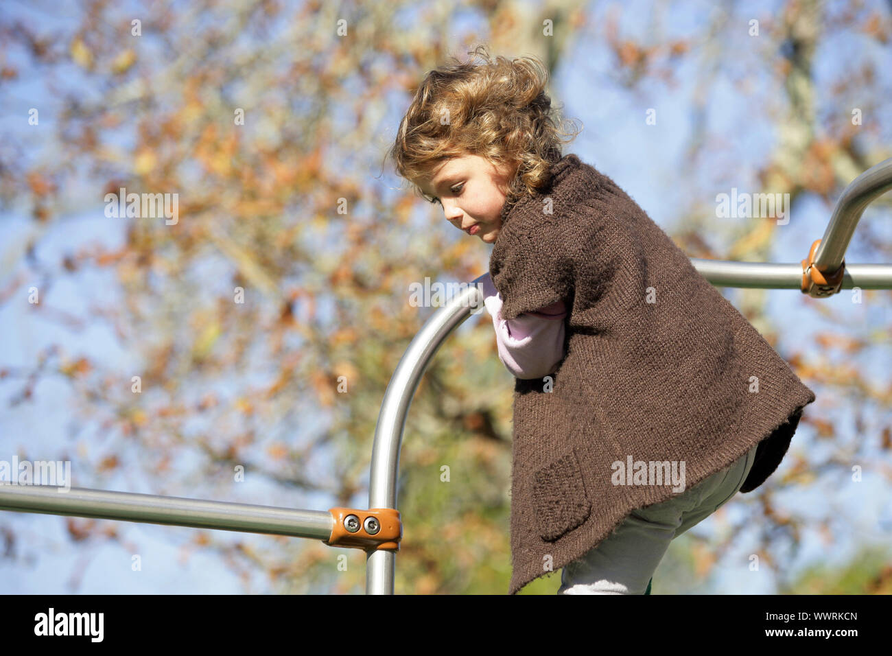 Little girl playing on climbing frame Stock Photo - Alamy
