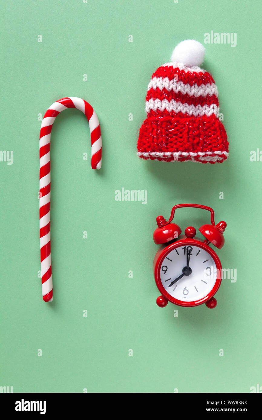 Christmas candy cane, clock and hat on pastel green backdrop. Winter ...