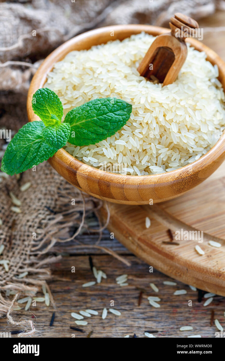 Bowl with long grain rice, shovel and a sprig of mint Stock Photo - Alamy