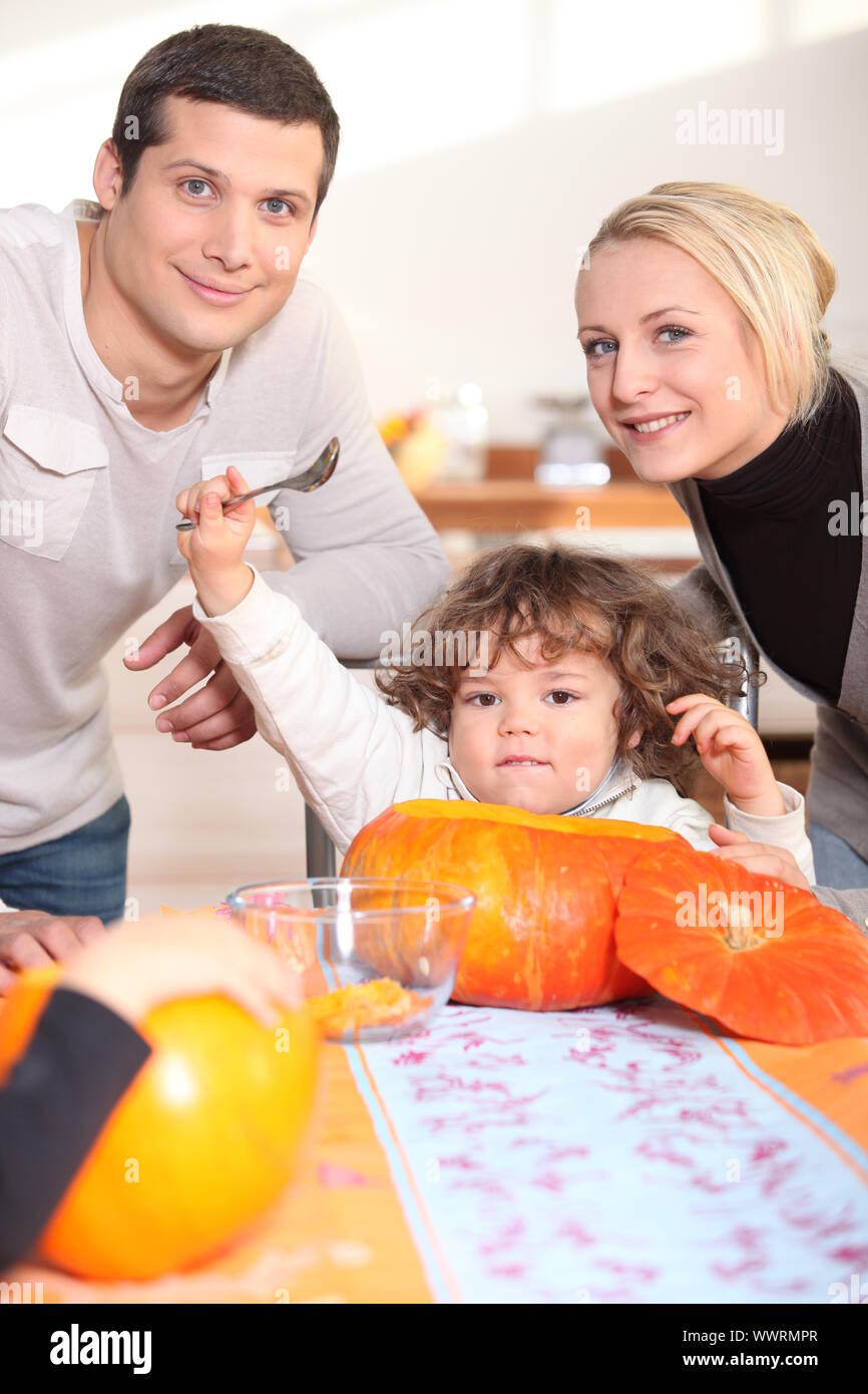 a little child eating a pumpkin and his parents Stock Photo - Alamy