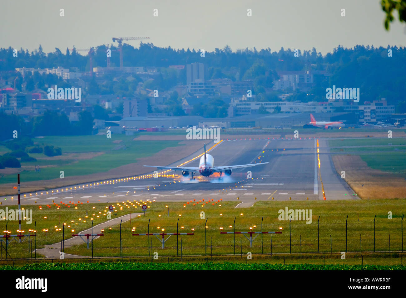 Airplane landing at airport runway, back view Stock Photo - Alamy