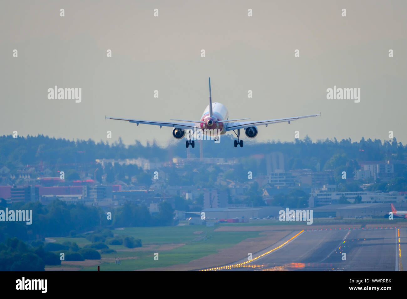 Airplane landing at airport runway, back view Stock Photo - Alamy