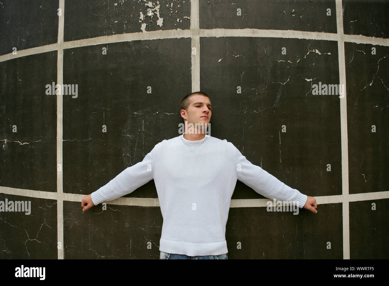 Man standing against a wall Stock Photo - Alamy