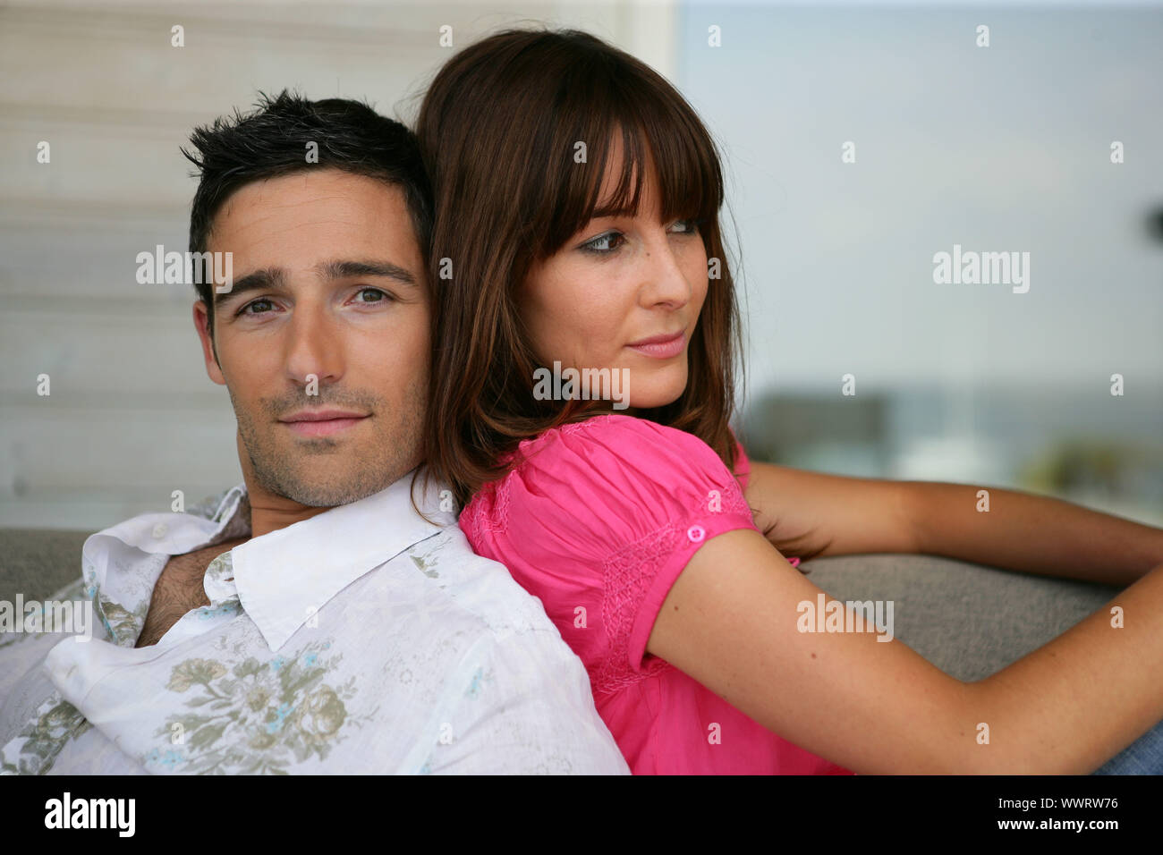 Couple sat back to back on the porch Stock Photo - Alamy
