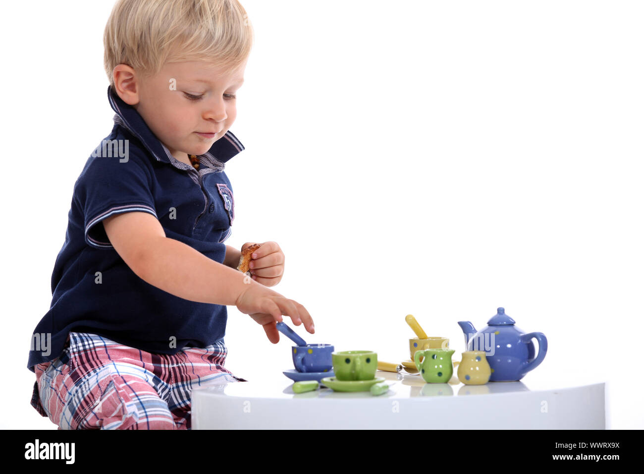 little boy playing with a doll's tea set Stock Photo - Alamy