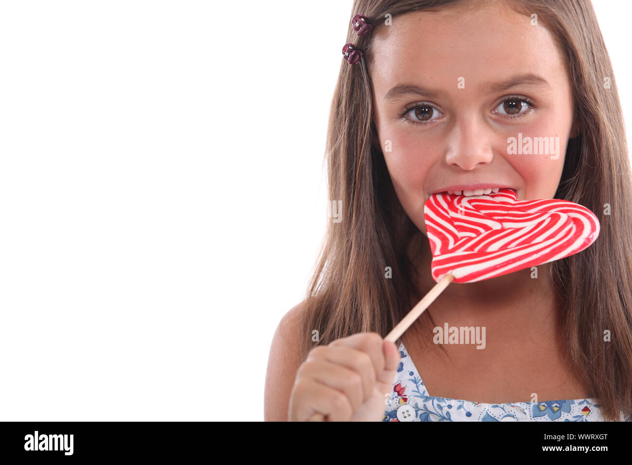 Young girl eating a heart shaped lolly Stock Photo - Alamy