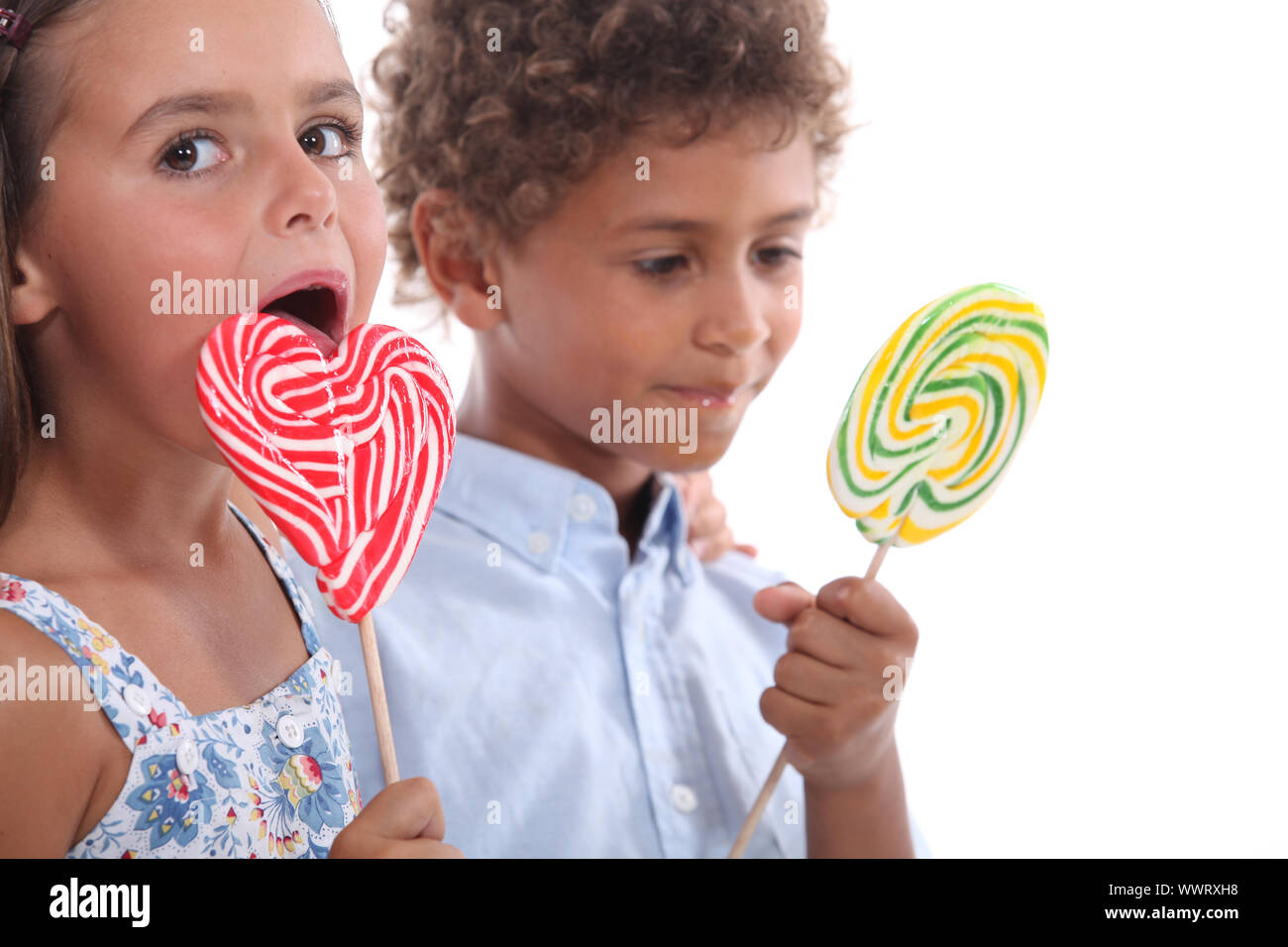 Closeup of two children eating lollipops Stock Photo - Alamy