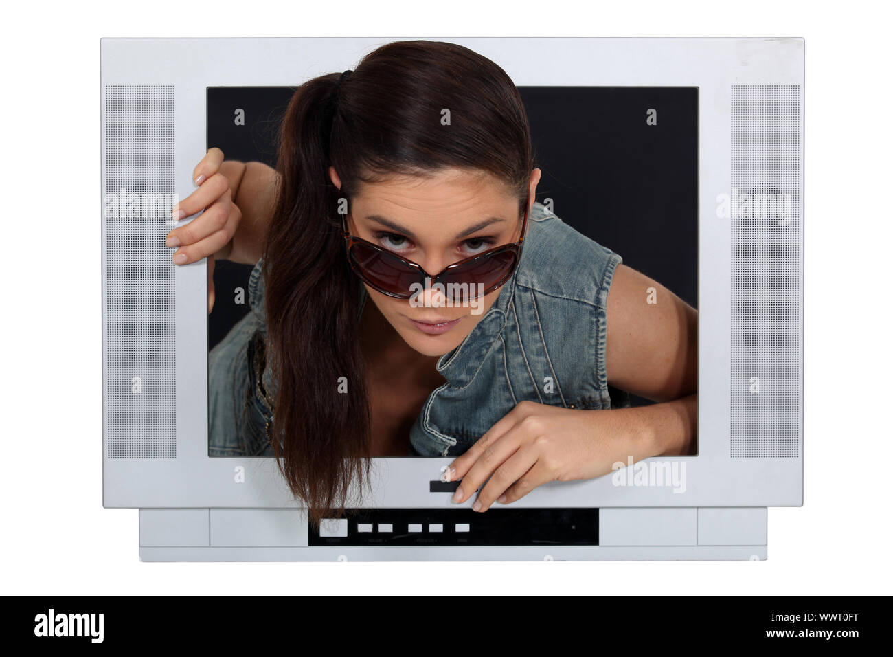 Woman climbing out of a TV set Stock Photo - Alamy
