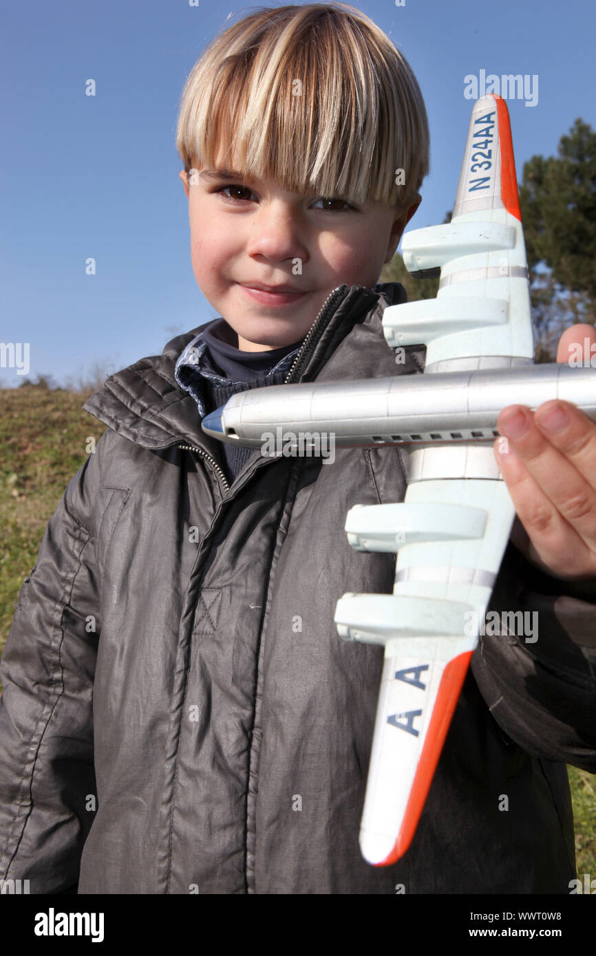Little boy playing with model plan Stock Photo - Alamy