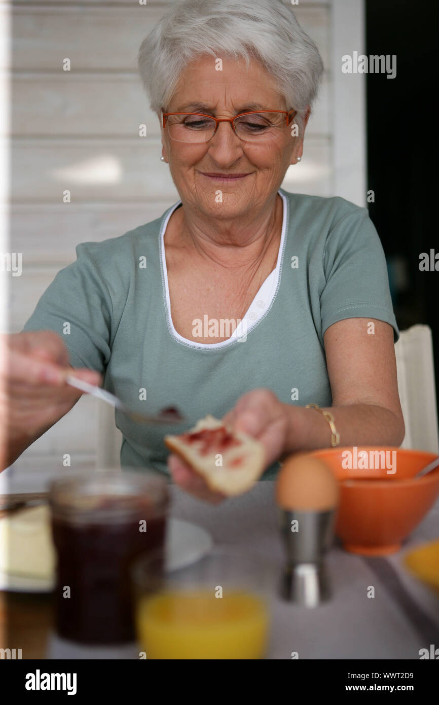 Elderly woman eating balanced breakfast Stock Photo - Alamy
