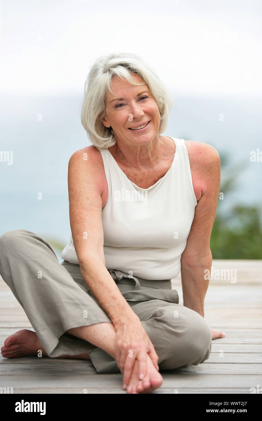 Old lady sat on wooden walkway Stock Photo - Alamy