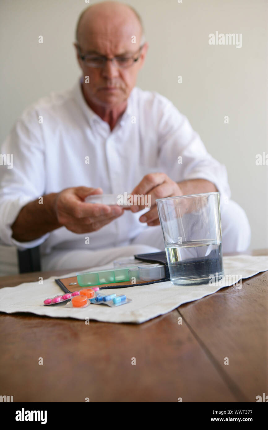 Elderly man taking medication Stock Photo - Alamy