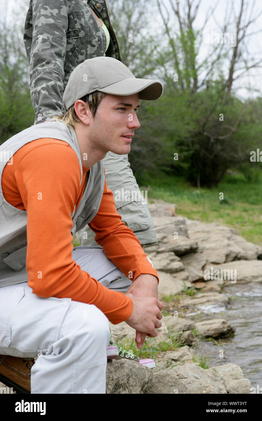 Man sitting at a riverside Stock Photo - Alamy