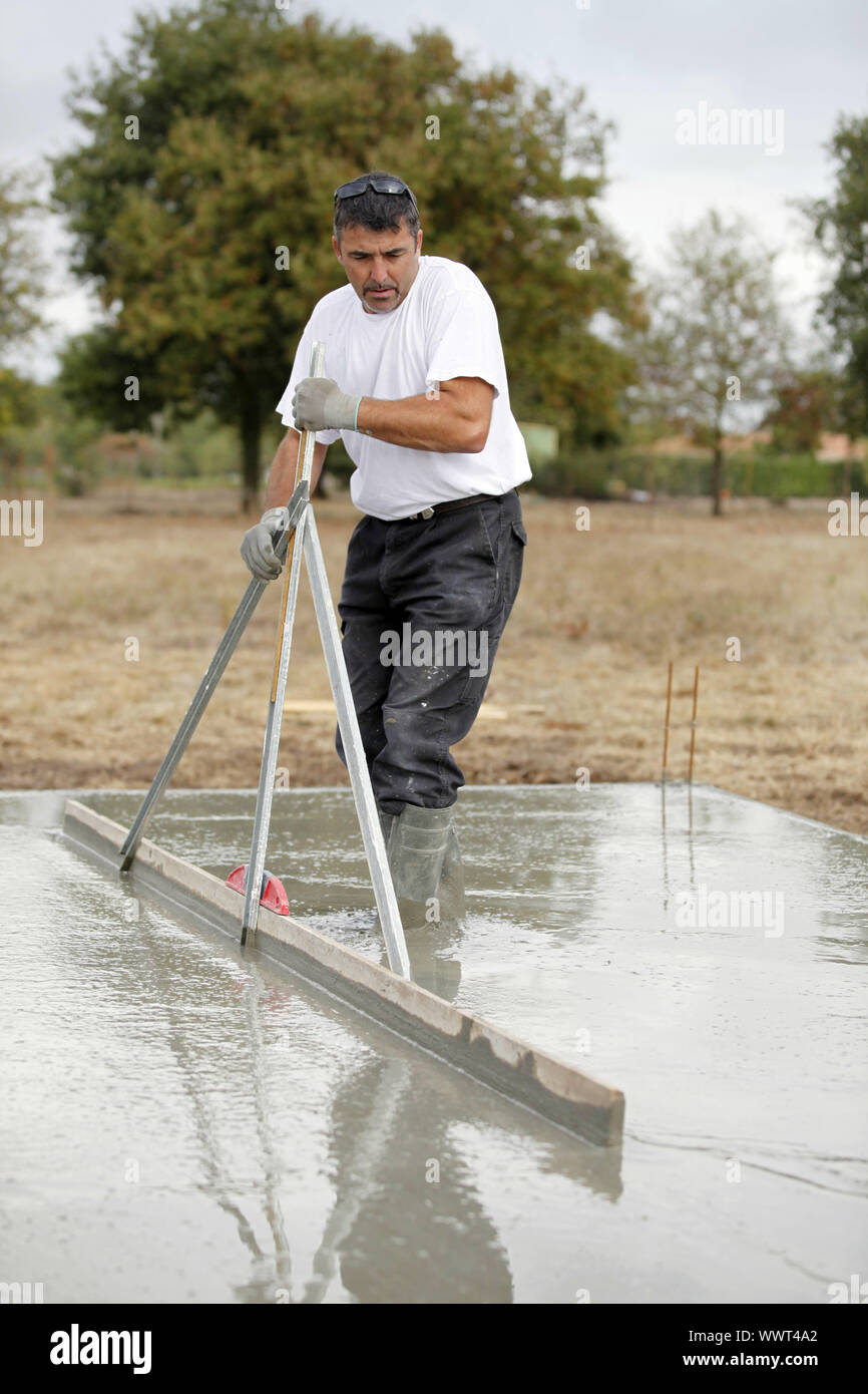 Builder smoothing a concrete foundation Stock Photo - Alamy