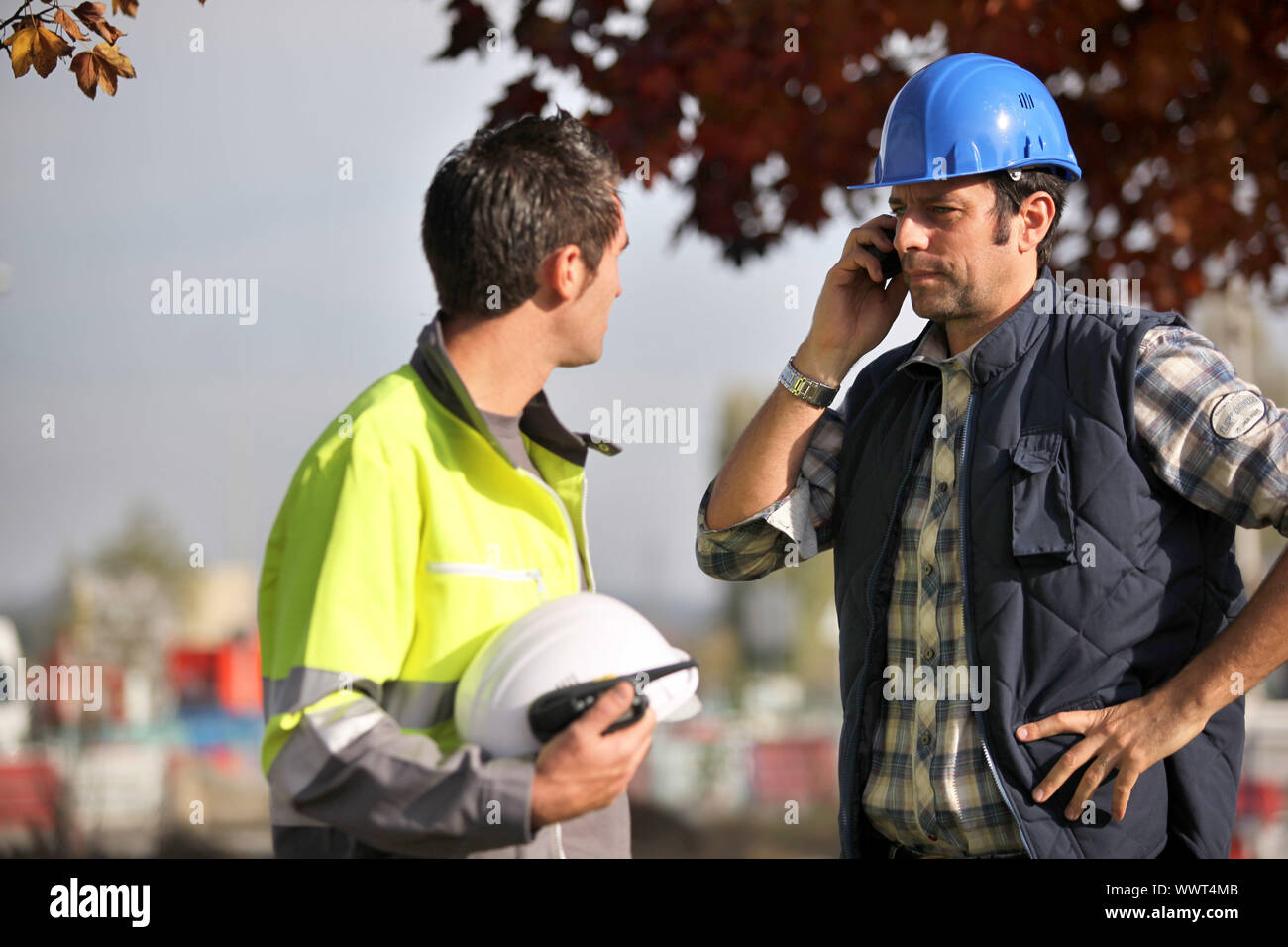 Construction workers on site with a phone Stock Photo - Alamy