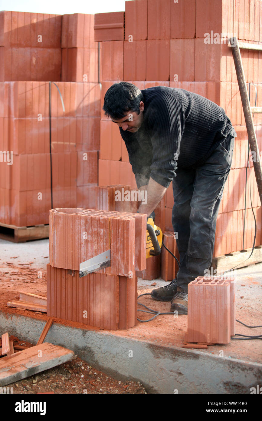 Builder cutting blocks to size Stock Photo - Alamy