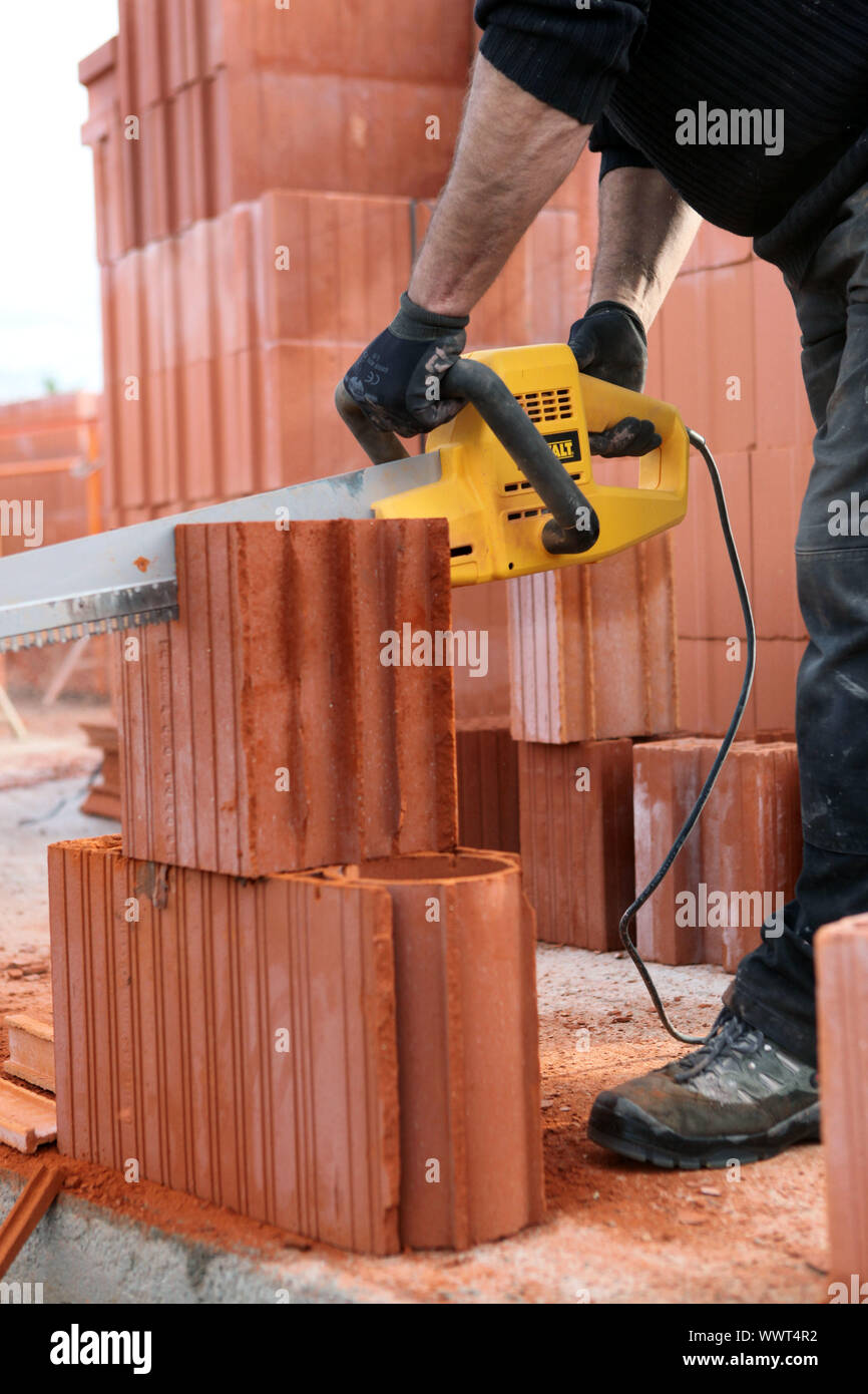 Builder cutting bricks to size Stock Photo - Alamy