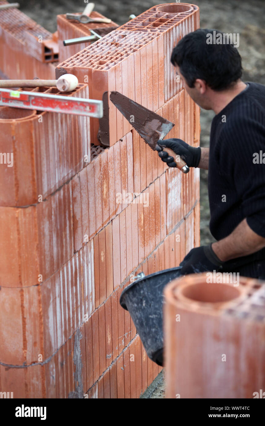 Builder with a block wall Stock Photo - Alamy