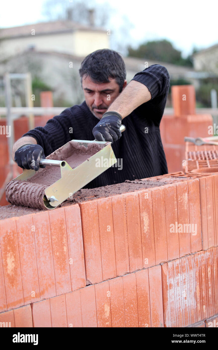 Builder laying blocks Stock Photo - Alamy