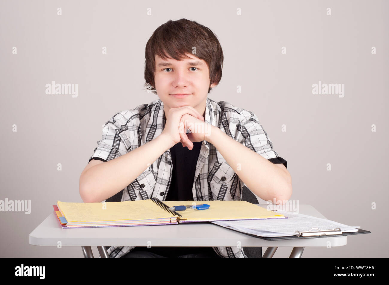 student in exams, sits at the table and reading a book Stock Photo - Alamy