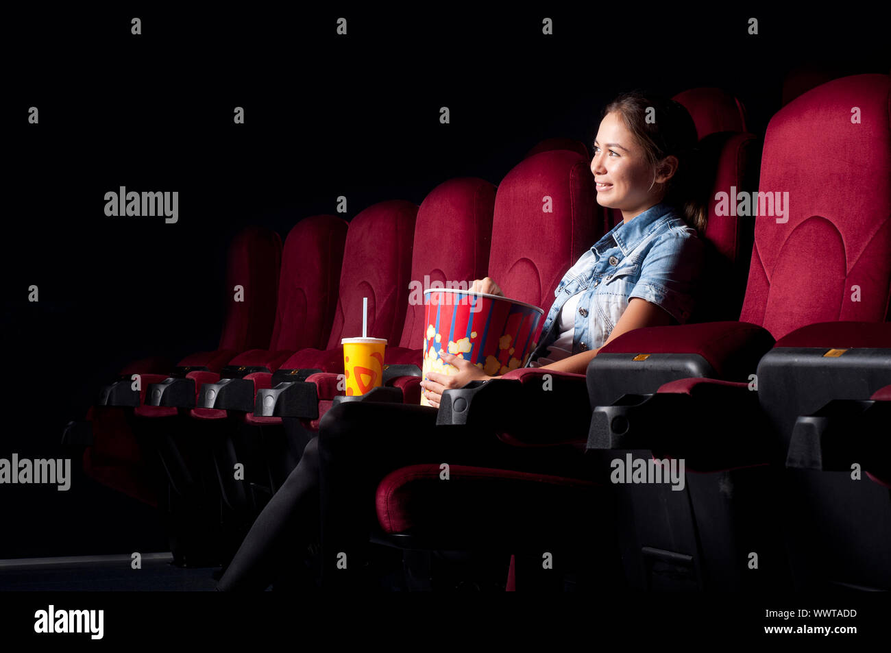 young woman sitting alone in the cinema and watching a movie Stock ...
