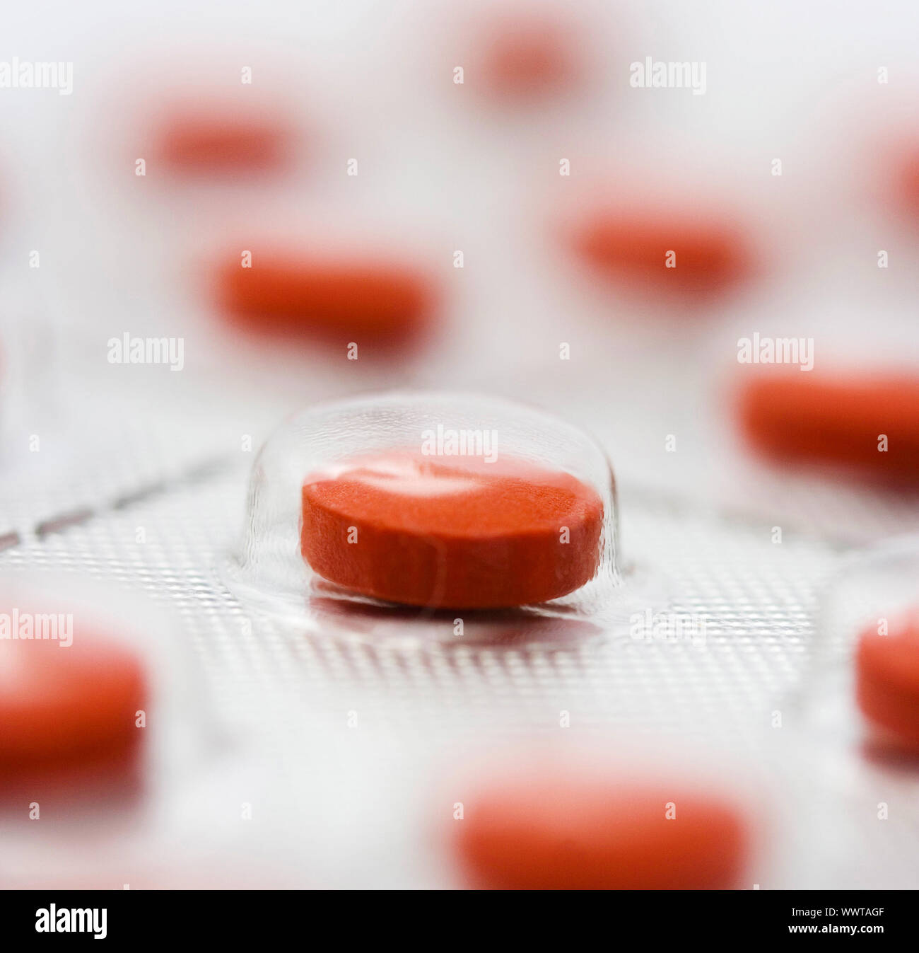 Red pills in plastic pack for an illness or headache Stock Photo - Alamy