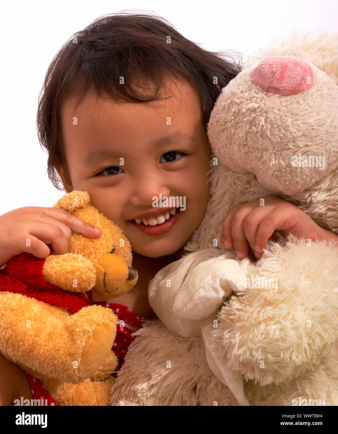 Happy Little Girl Cuddling And Hugging Her Soft Toys Stock Photo - Alamy
