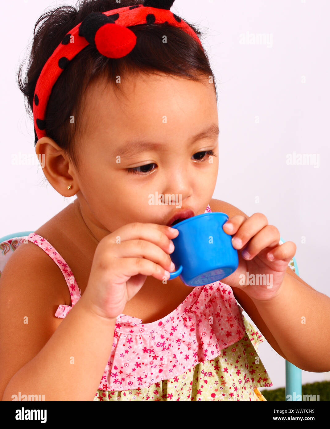 Kid Play Acting At Drinking Tea In A Small Cup Stock Photo - Alamy