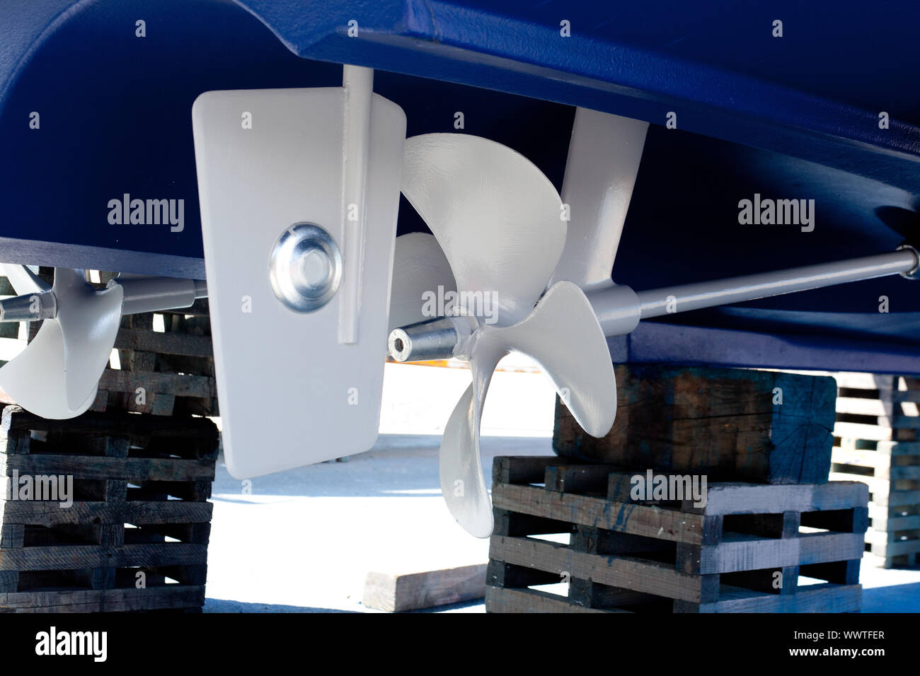 gray painted propeller and steering with zinc anodes in blue hull Stock ...