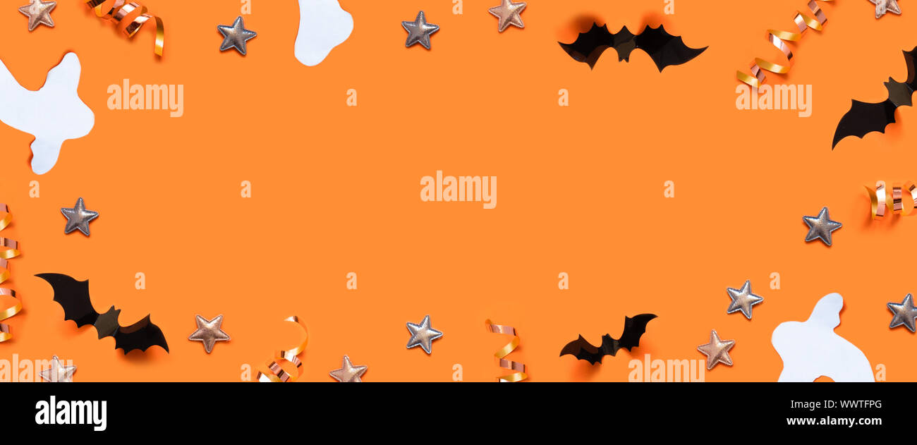 Halloween decor frame with bats, ghost, spider web, stars over a orange ...
