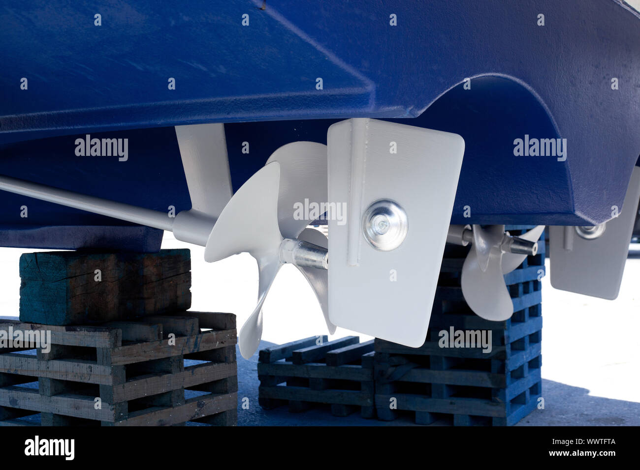 gray painted propeller and steering with zinc anodes in blue hull Stock ...