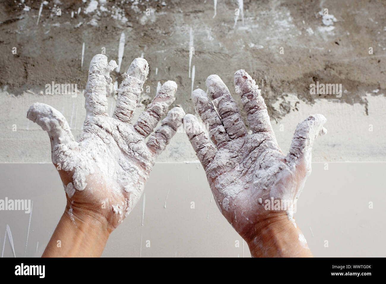 Artist plastering man hands with white dried cracked plaster texture in ...