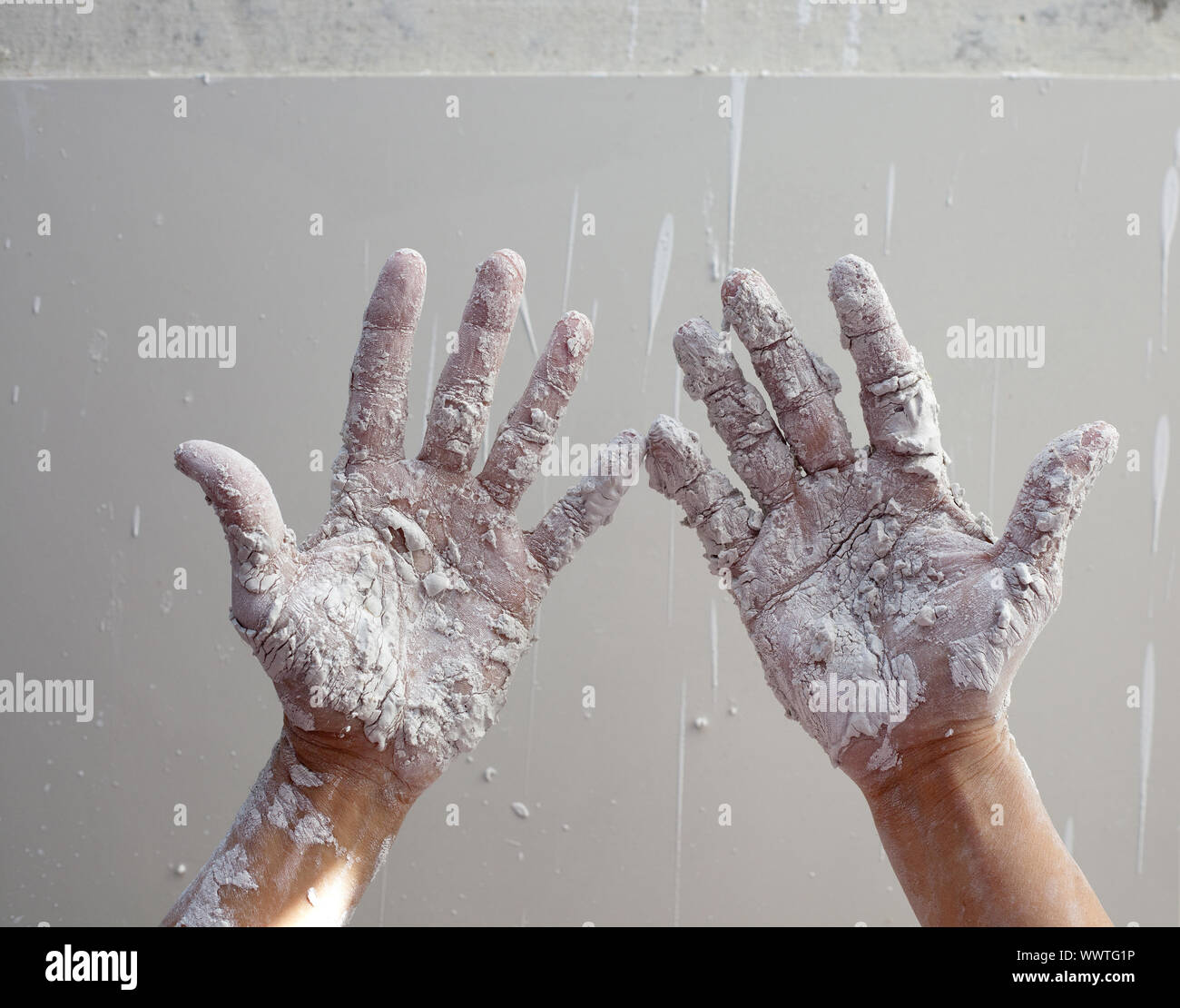 Astist plastering man hands with white dried cracked plaster texture in ...