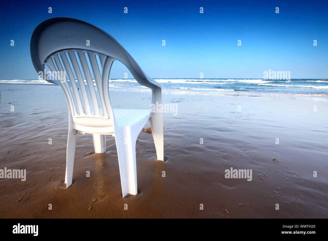 chair on sand and ocean background Stock Photo - Alamy