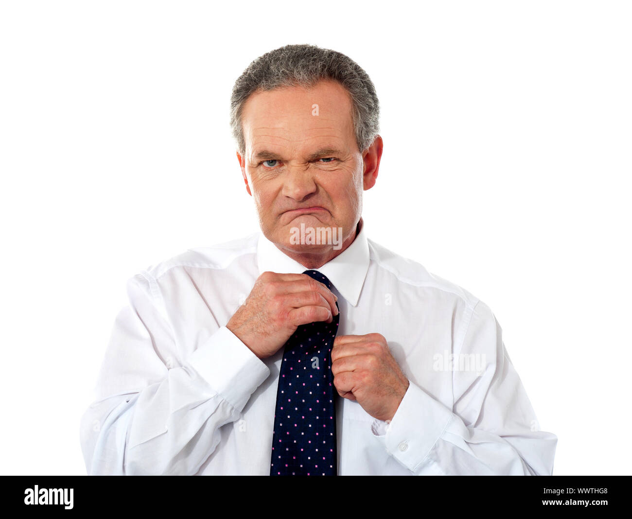 Serious businessman adjusting his tie, irritation on his face Stock ...
