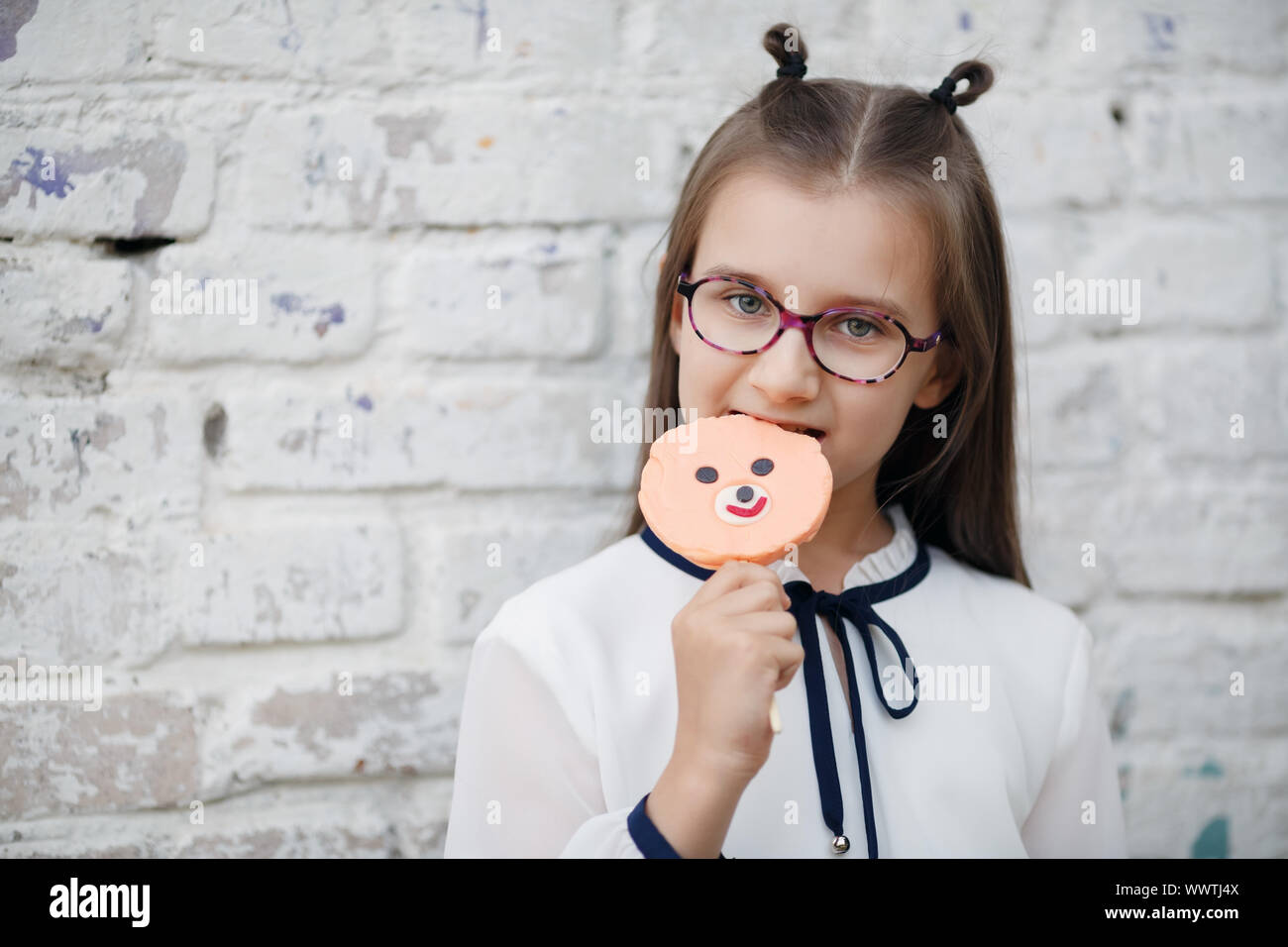 Girl Eating Big Lollipop Schoolgirl With Candy On Brick Wall