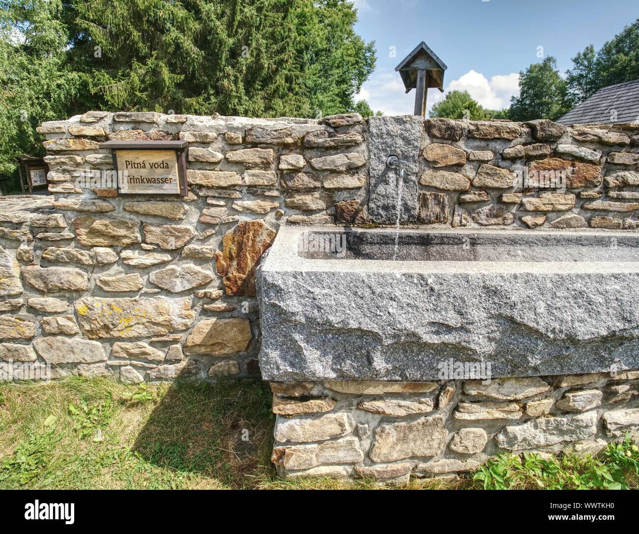 Mountain spring of pure, clear, fresh water with water tap trough in ...