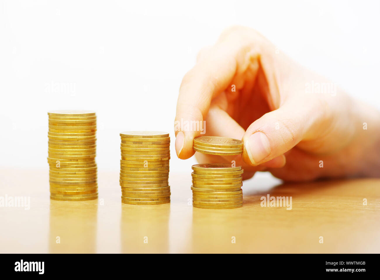 Hand put coin to money staircase isolated on white background Stock ...