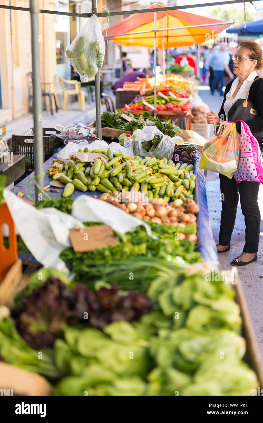 Women buy from greengrocer on the farmers market in Tymbaki, Crete ...
